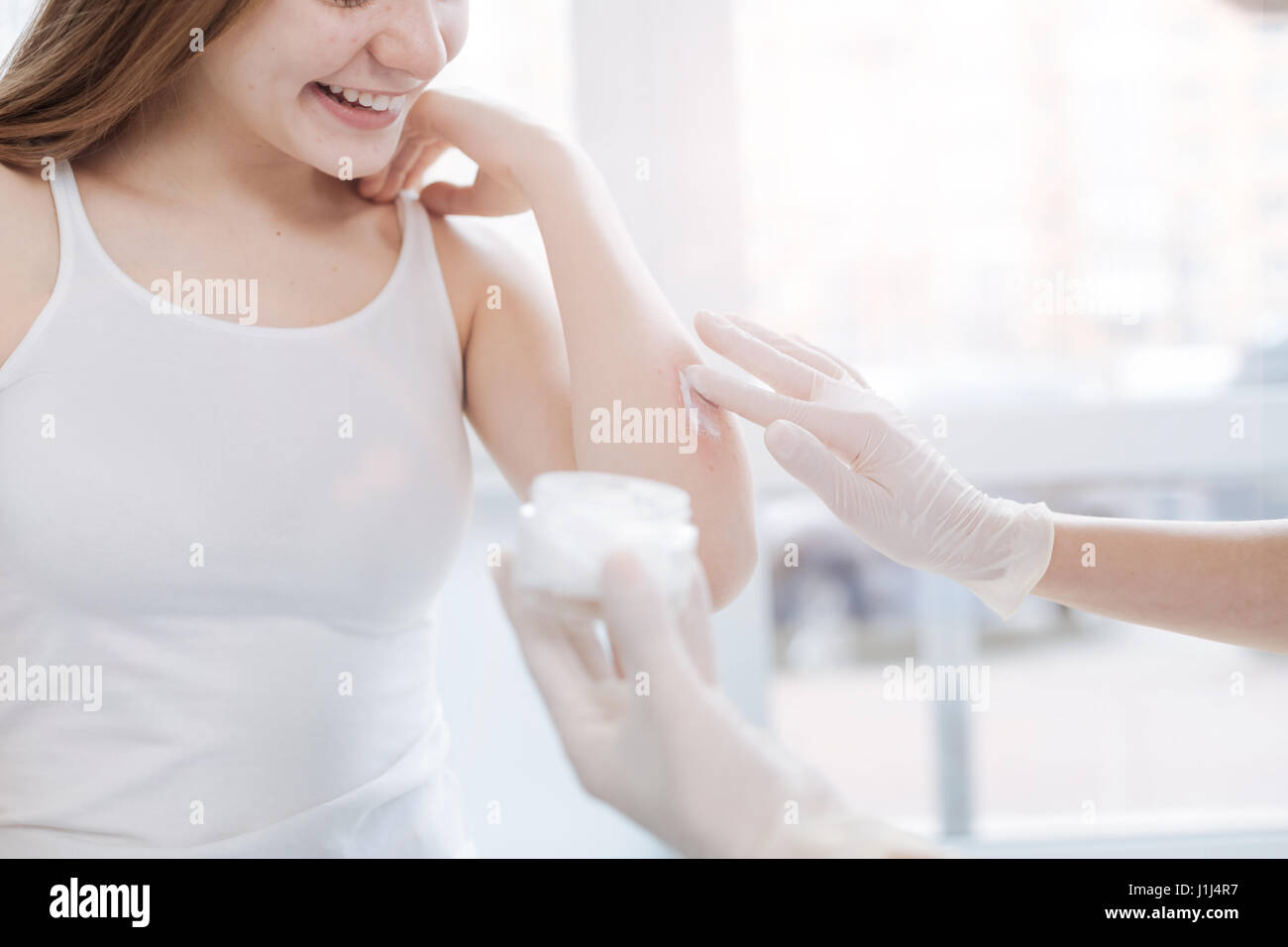 Professional practitioner testing new medical cream on patient skin at ...