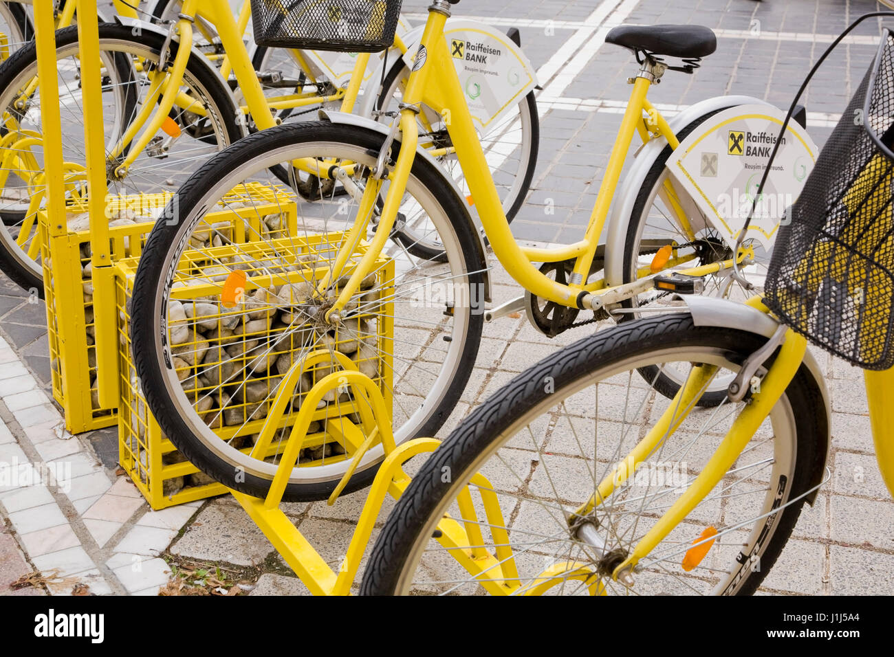 Yellow rental bicycles parked in a bicycle rack in the town of Brasov ...