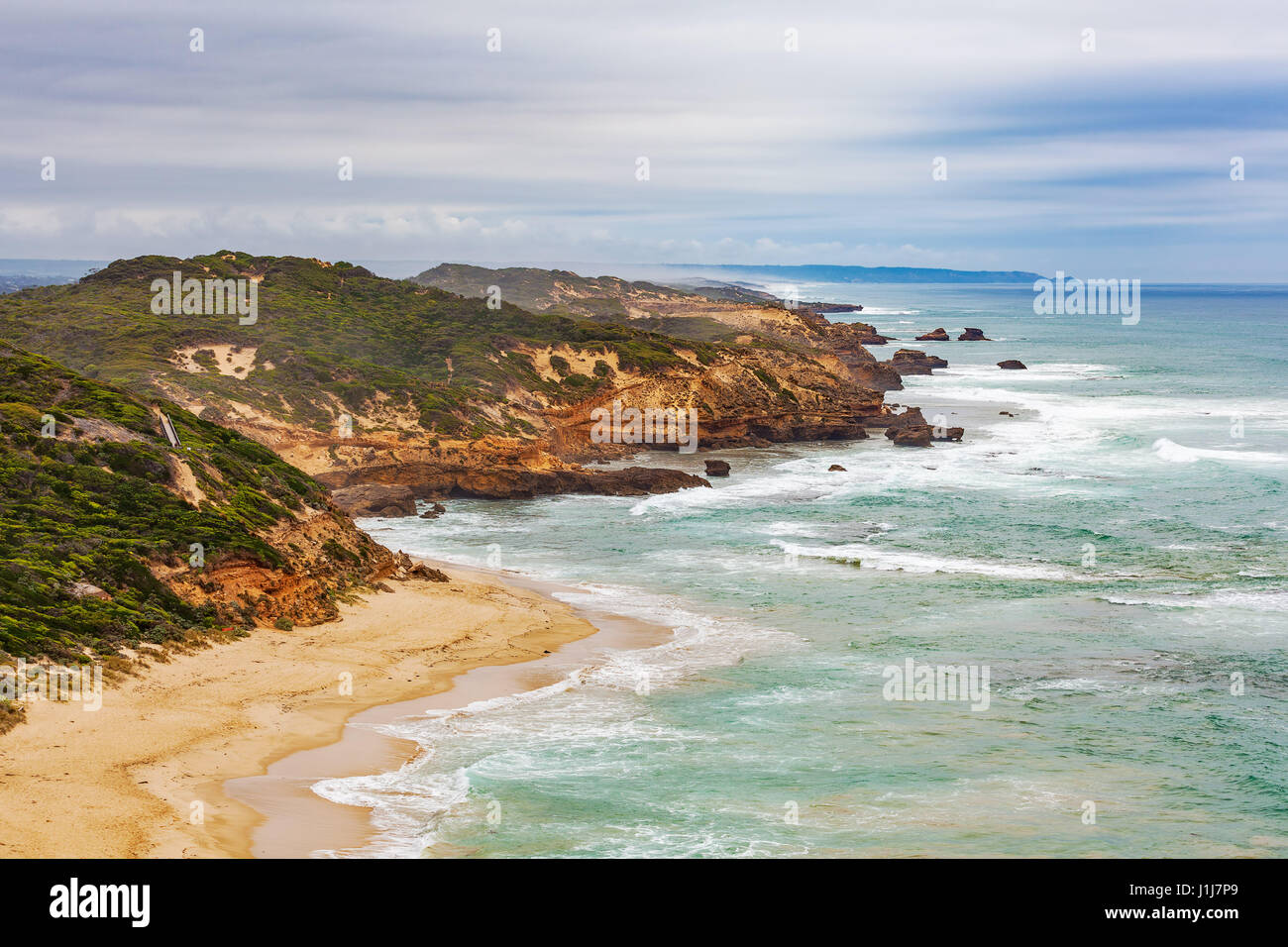 Rugged coastline, coastal vegetation, breaking waves, and eroded rocks ...