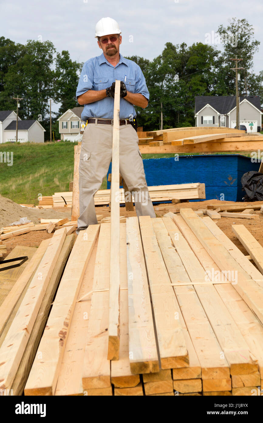 Carpenter inspecting wood before selecting the next support beam Stock ...