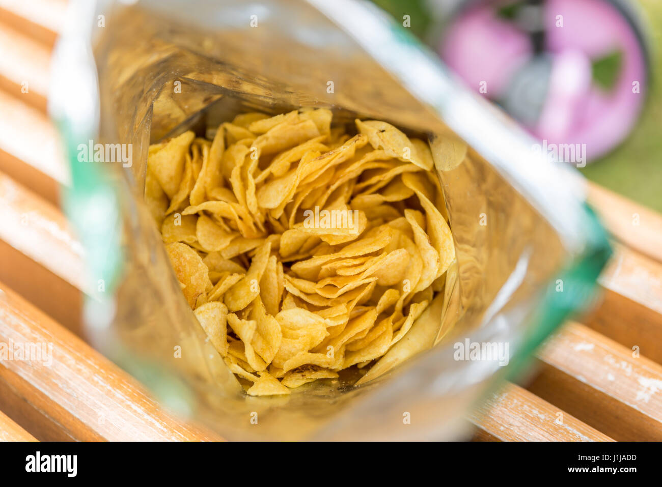 potato crisps in bag on wooden bench outdoor Stock Photo - Alamy