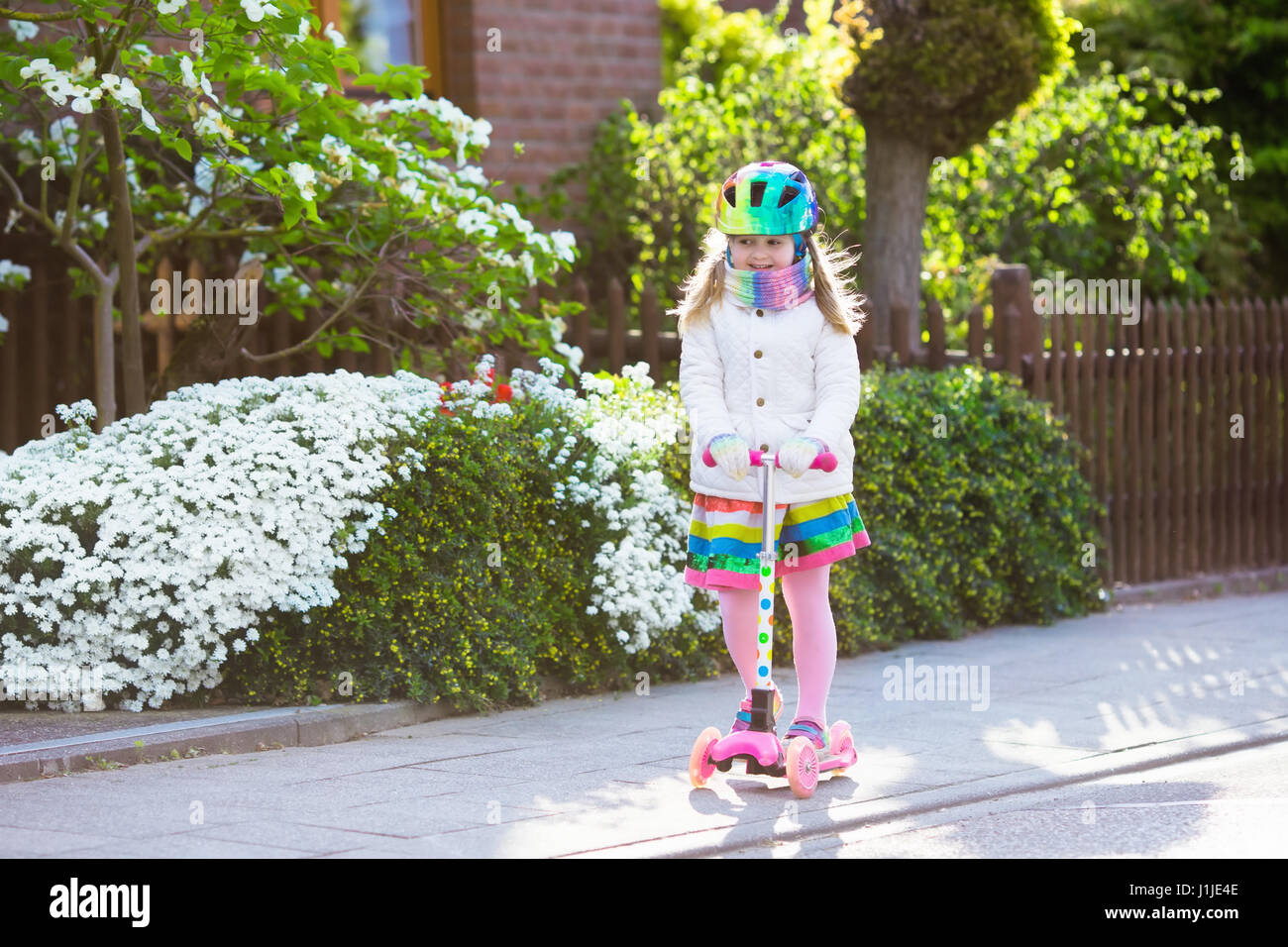 Child riding scooter on way back to school. Little girl playing ...