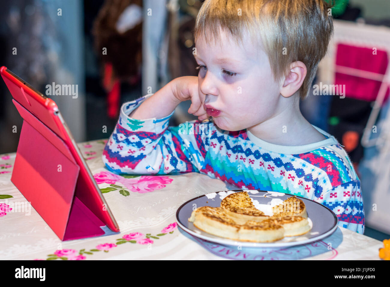 Little Boy watching digital tablet with face expression Stock Photo - Alamy