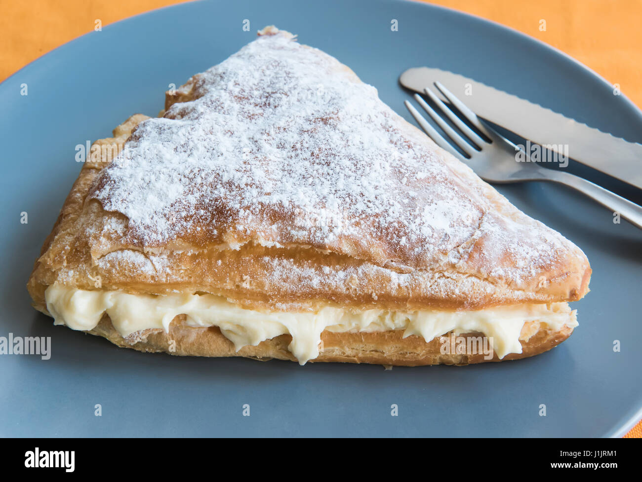 Folded bun triangle with cream on a gray plate Stock Photo - Alamy