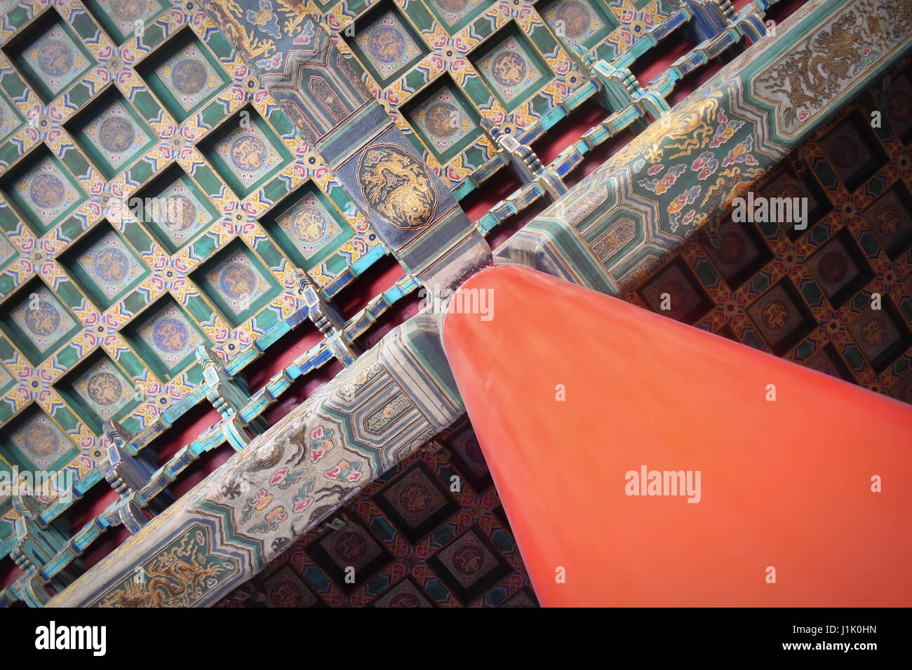 Looking up red column supporting beautifully decorated ceiling of ...