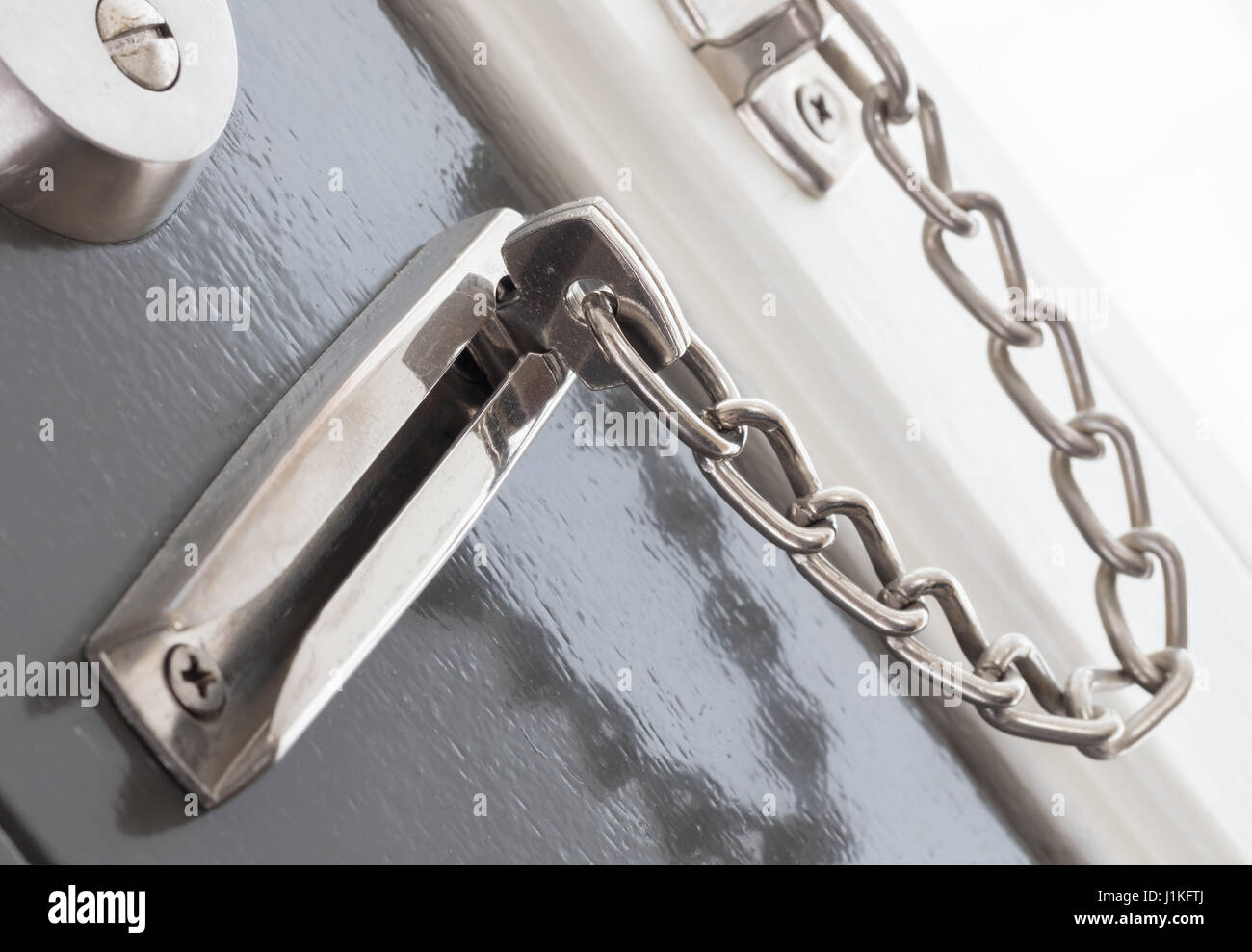 Door chain on a grey door, security measures Stock Photo - Alamy