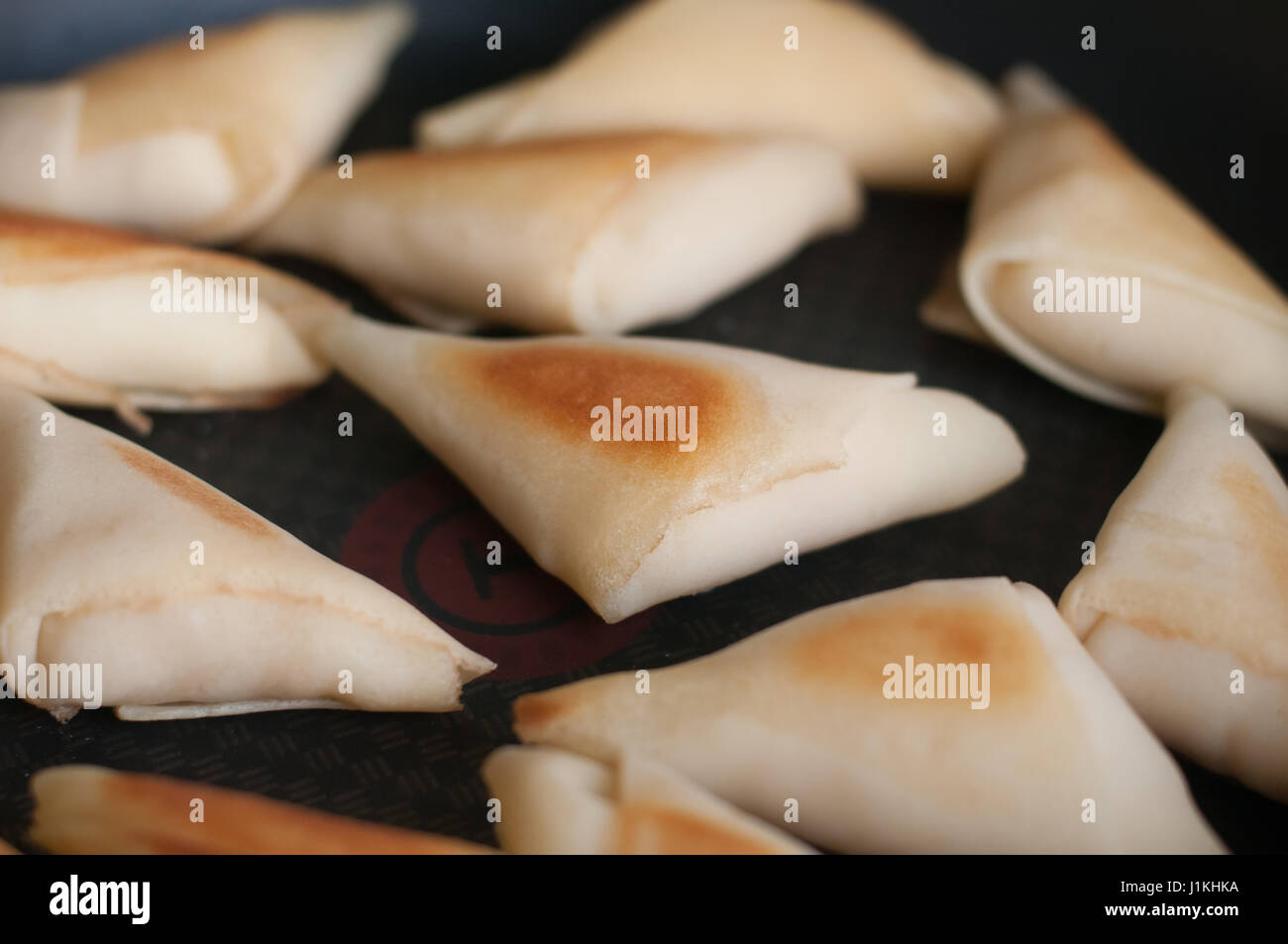 Many pancakes folded triangles on friyng pan almost top view Stock ...