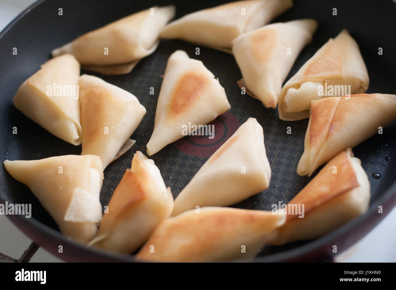 Many pancakes folded triangles on friyng pan almost top view Stock ...