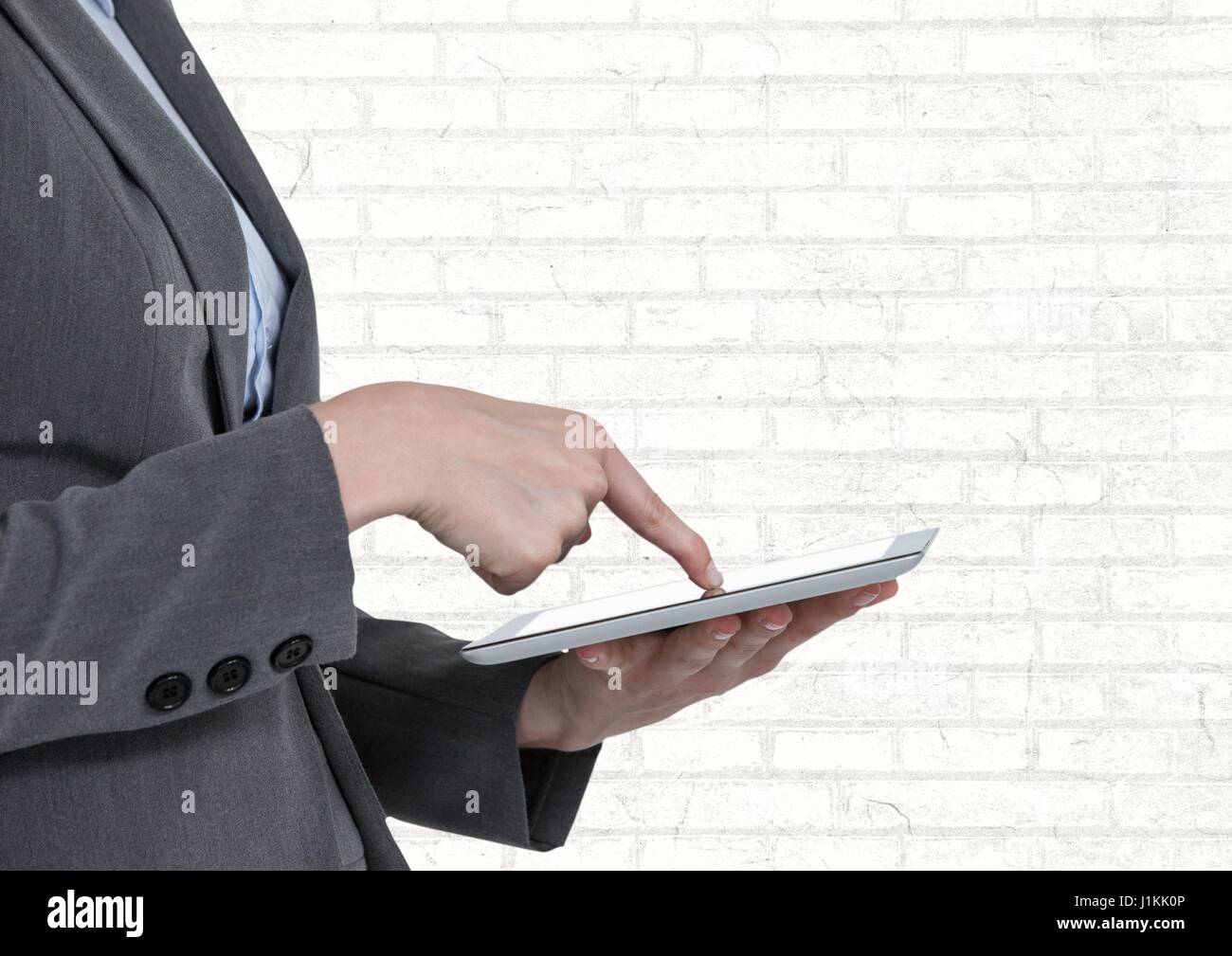 Digital composite of Man touching tablet with white brick wall Stock ...