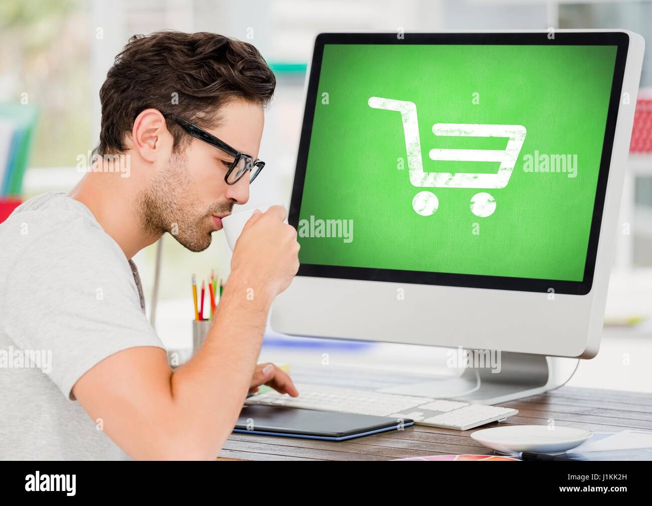 Digital composite of Man using Computer with Shopping trolley icon with ...