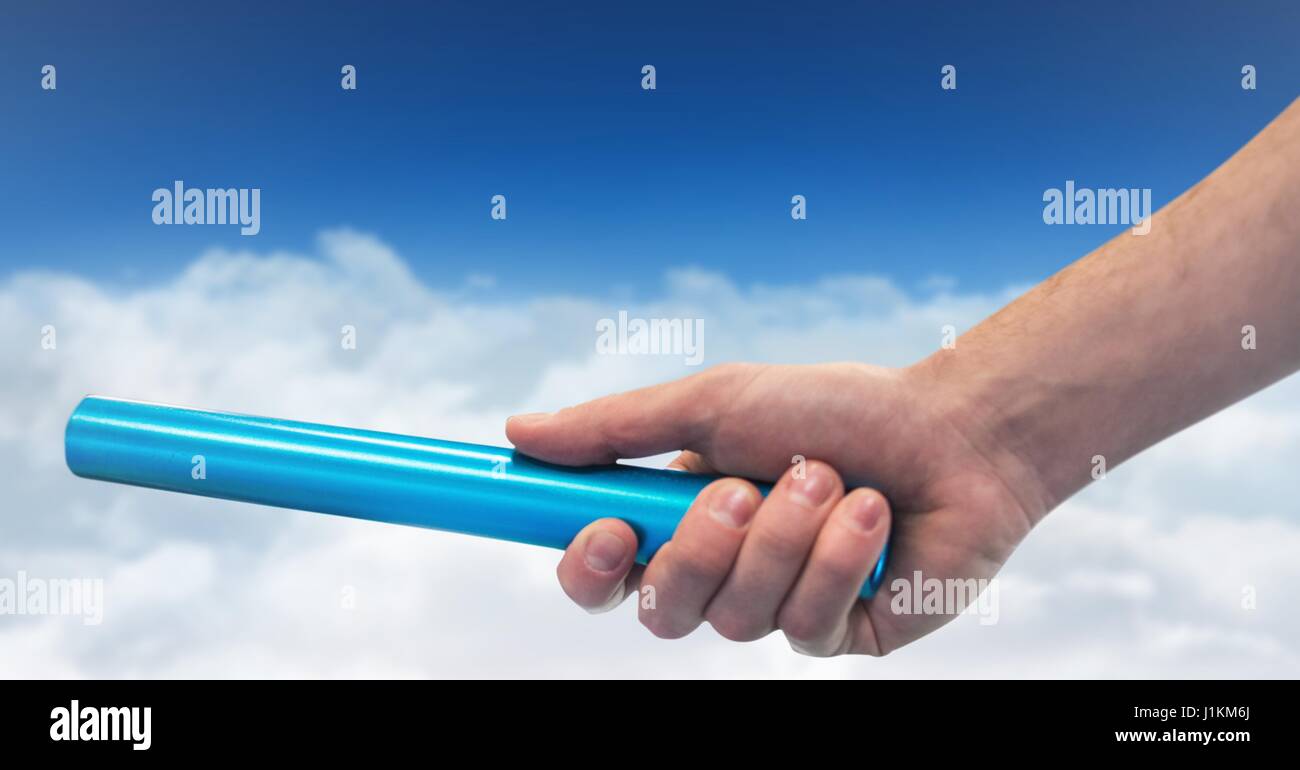 Digital composite of Hand with blue baton against clouds and blue sky ...