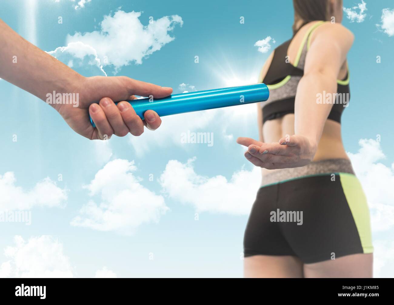 Digital composite of Relay runner and hand with blue baton against sky ...