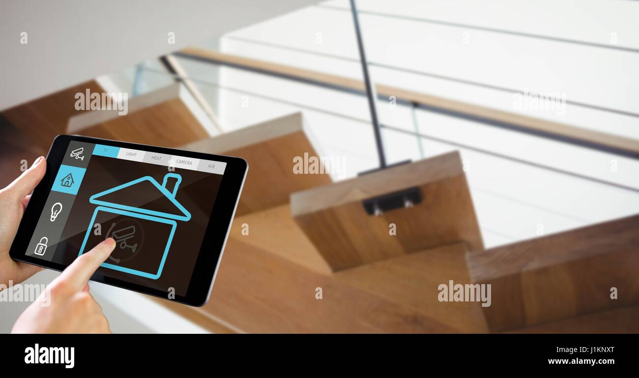 Digital composite of Hands using smart home app on tablet PC with ...