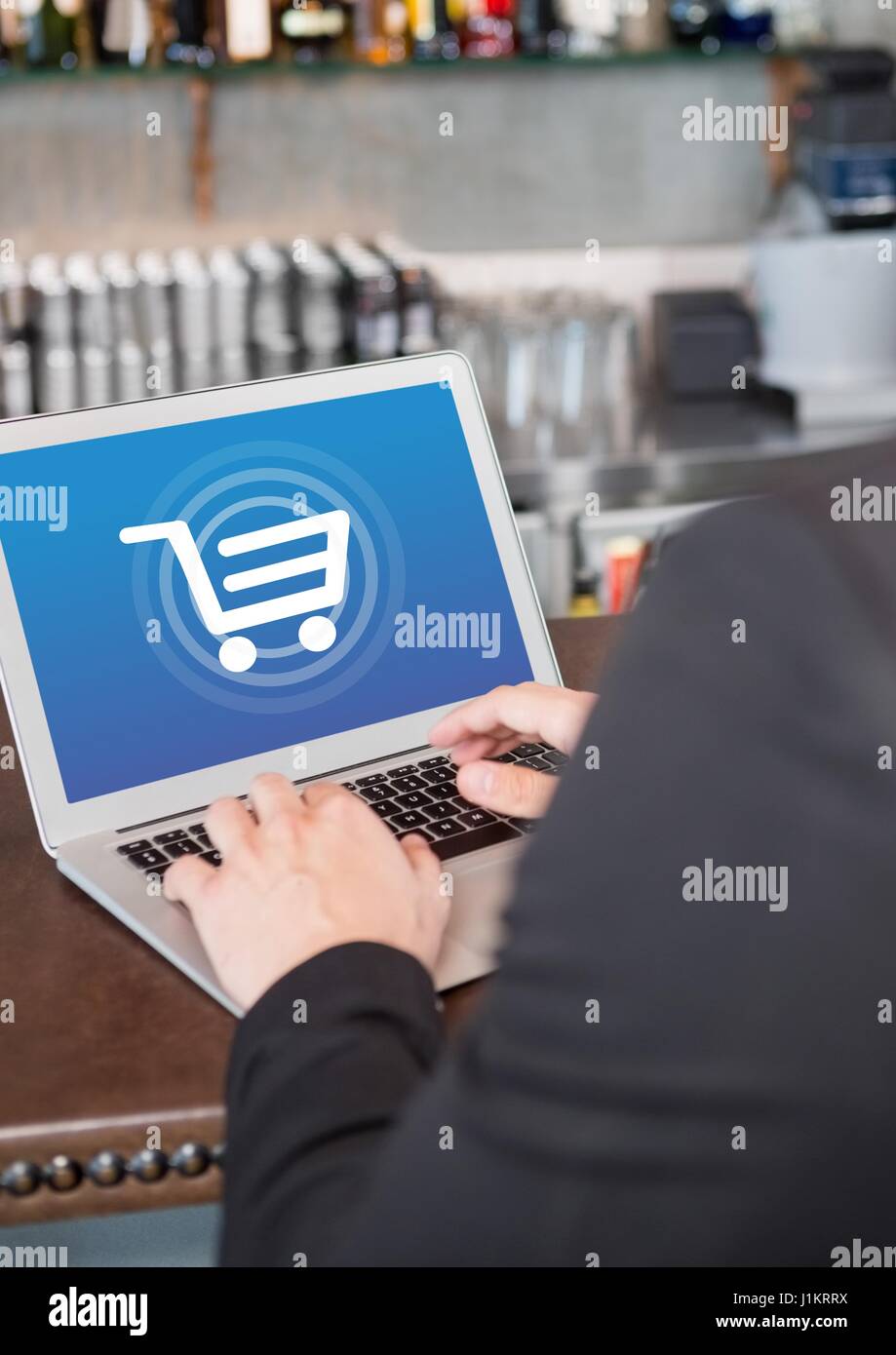 Digital composite of Person using Laptop with Shopping trolley icon ...