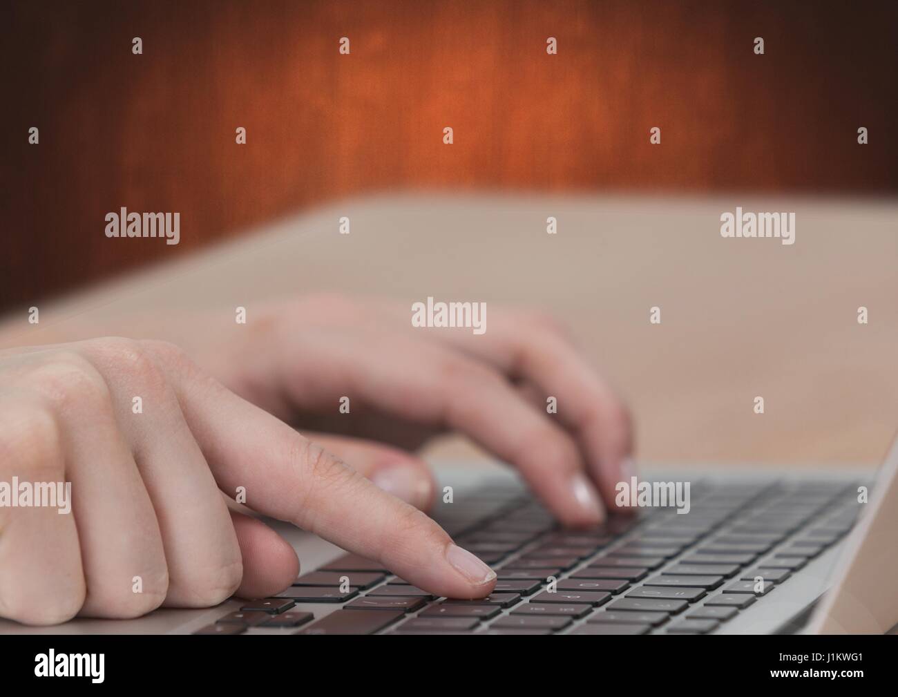Digital composite of Hand typing on laptop with brown background Stock ...