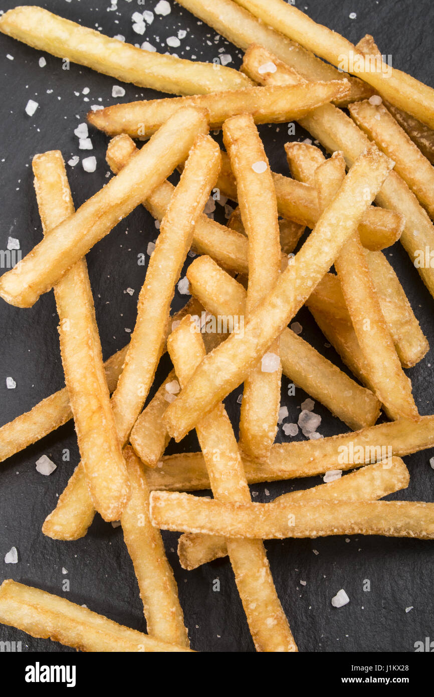 golden brown french fries with coarse salt on slate Stock Photo - Alamy