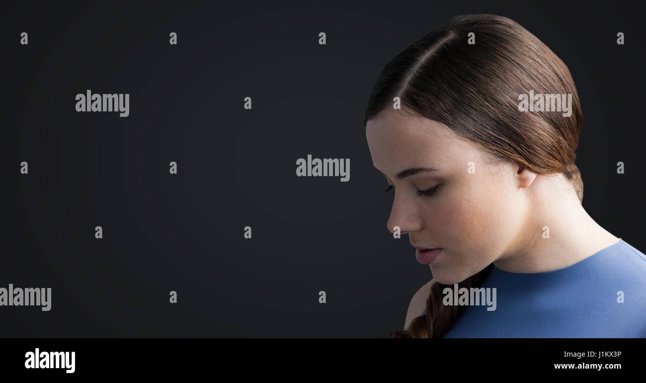 Digital composite of Woman looking down against dark grey background ...