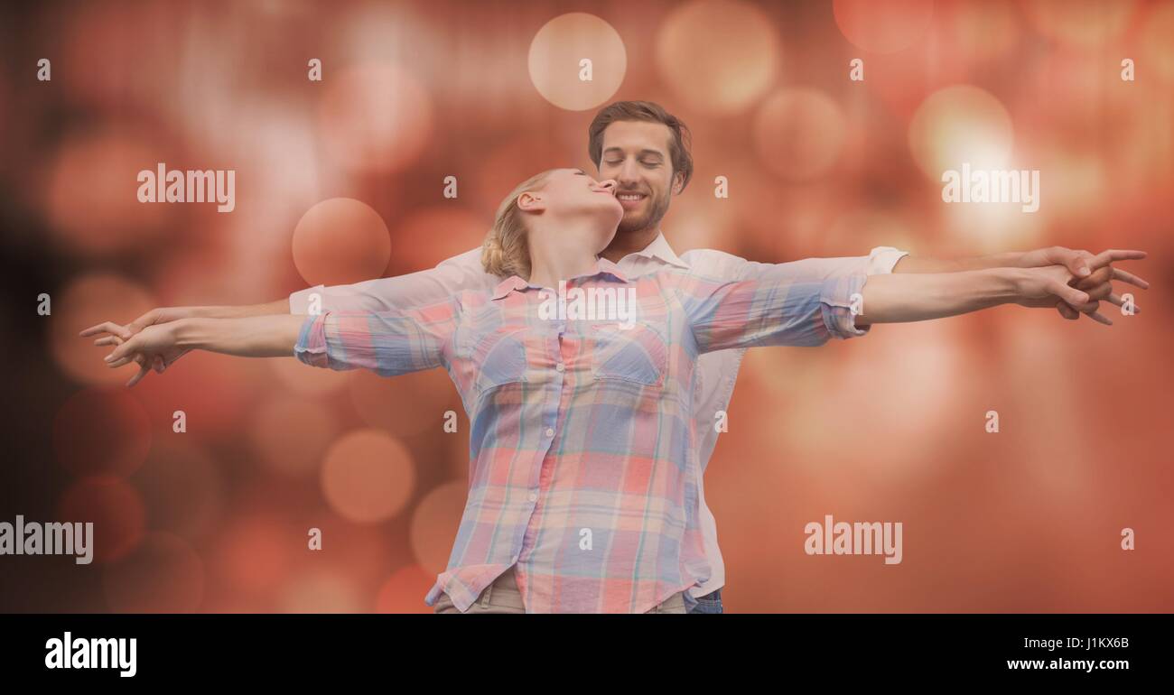 Digital composite of Loving couple with arms outstretched over blur ...