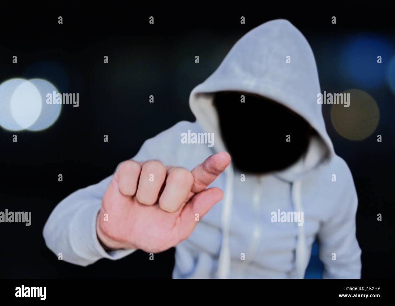 Digital composite of Anonymous Criminal Man in hood in front of city ...