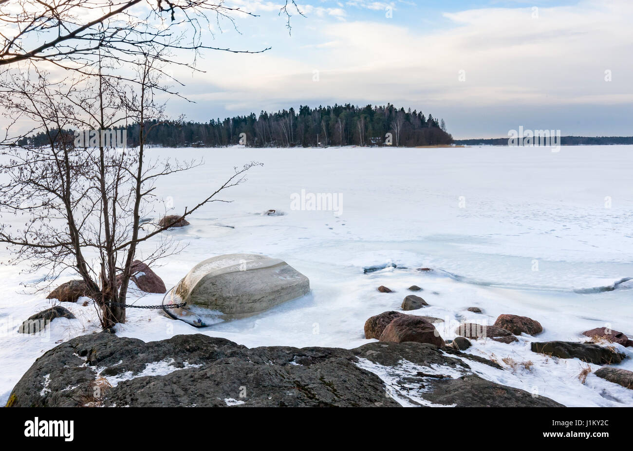 Small white oar boat upside down on frozen sea Stock Photo - Alamy