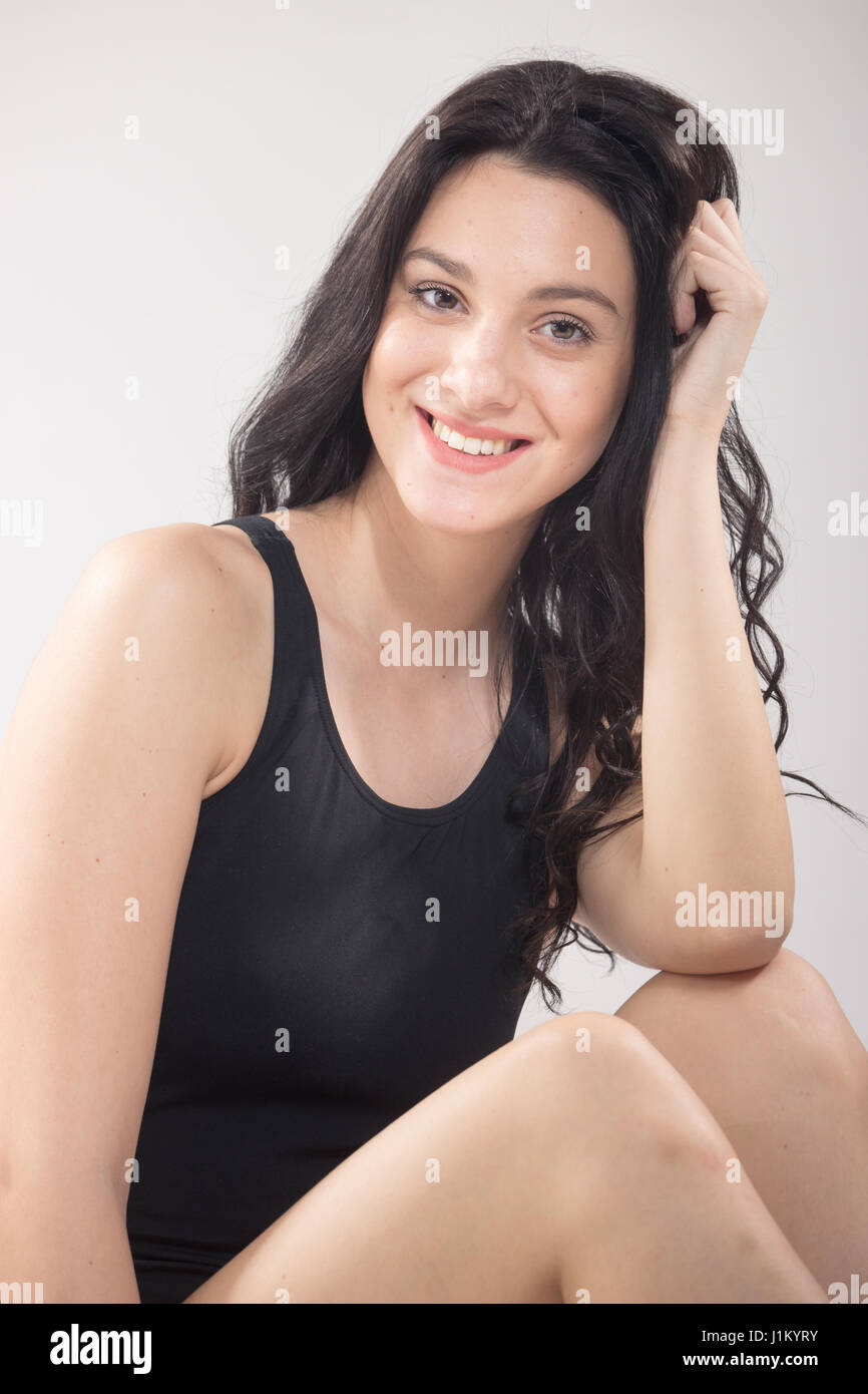 one young adult woman, smiling swimsuit, sitting upper body shot, white background Stock Photo ...