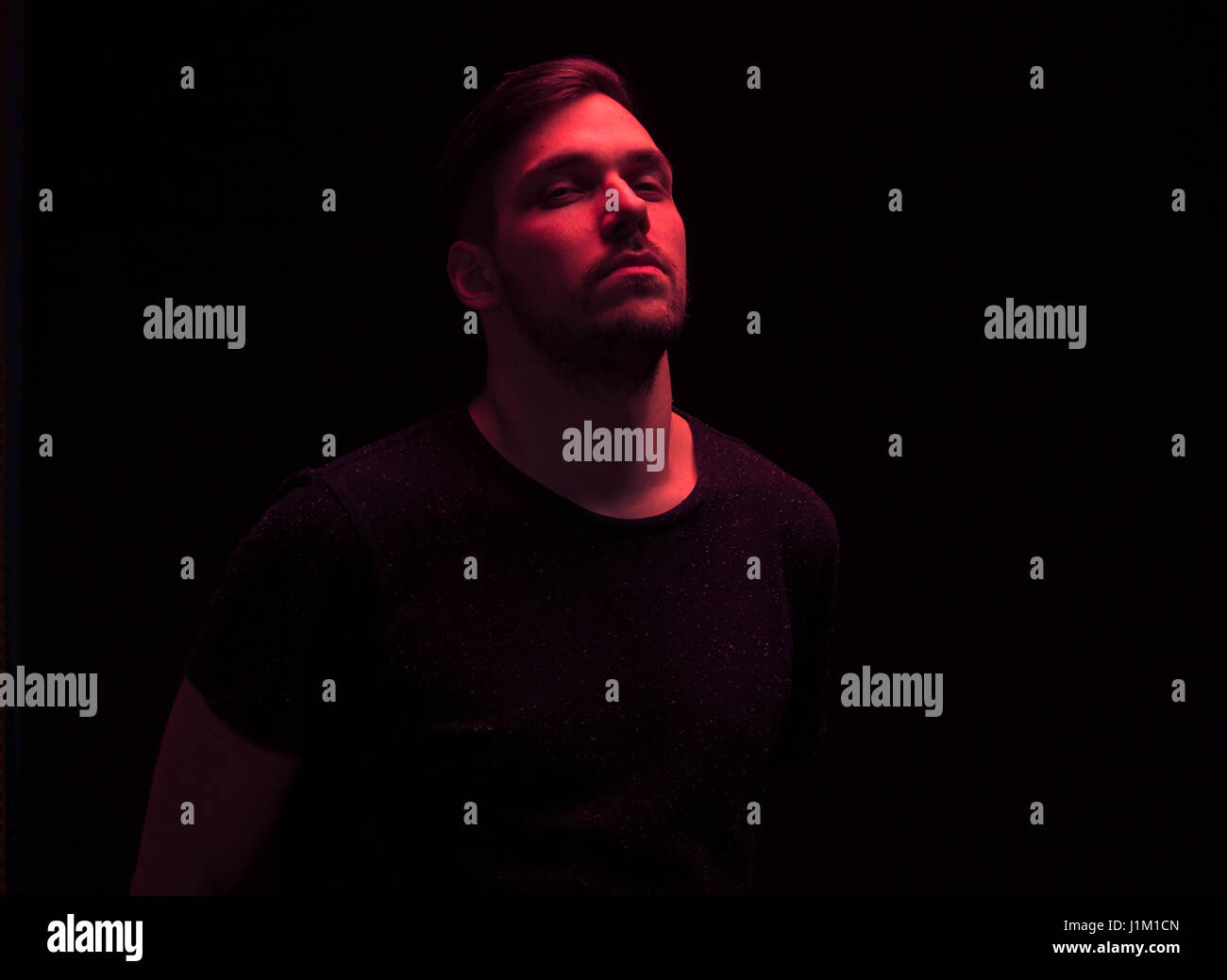 one young adult man, looking above, looking up, looking at camera, red ...