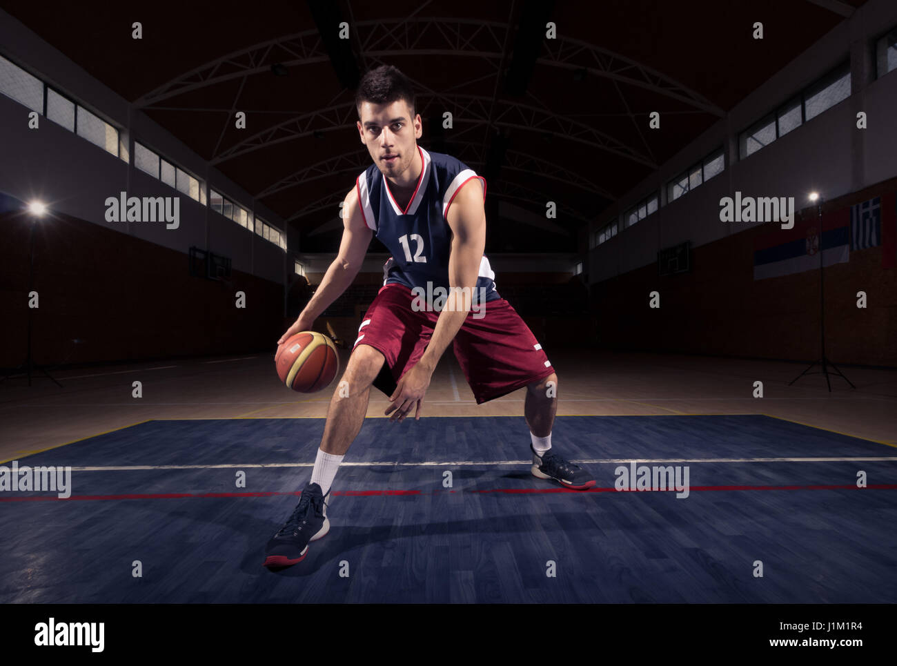 one young adult man, basketball player dribbling ball thought the legs ...