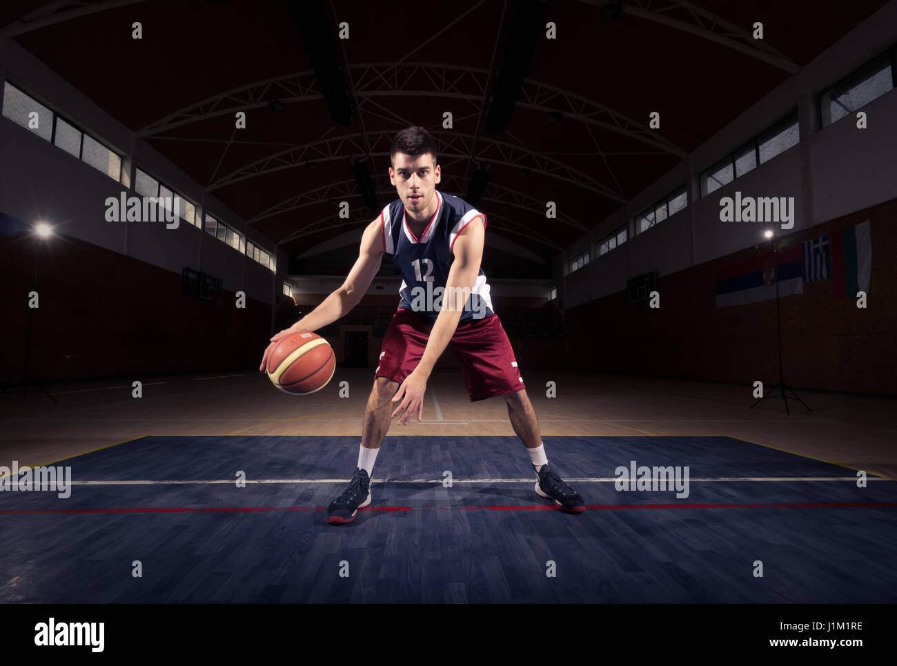 one basketball player dribbling ball, indoors, basketball court Stock ...