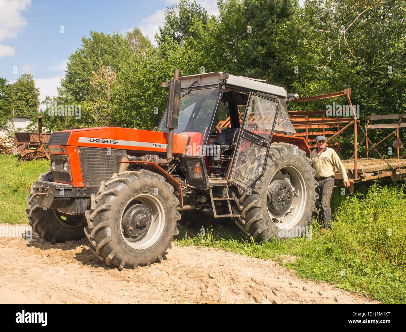 Wolka Zamkowa, Poland - August 13, 2016: Farmer by his big red tractor ...