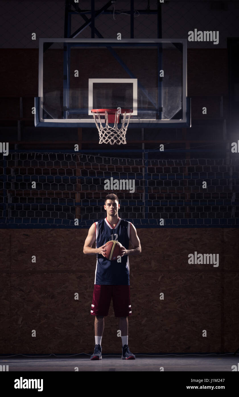 one young man, basketball player, holding ball, indoors basketball ...