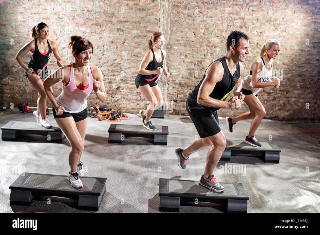 Group of fit people practicing on steeper, class of stepping Stock ...