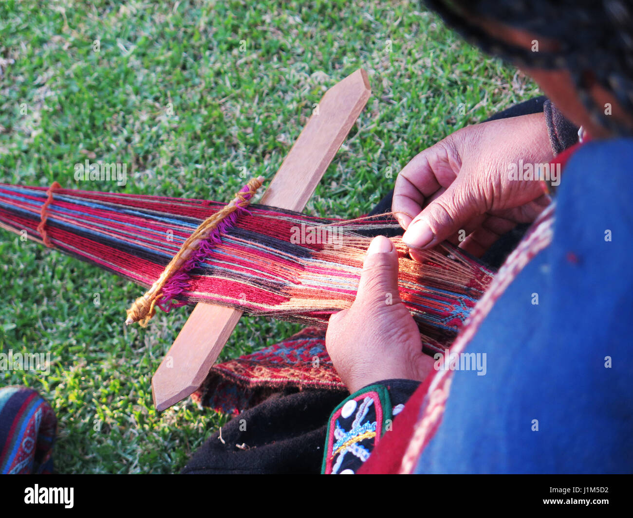 Close up of Peruvian lady in authentic dress spinning yarn by hand ...