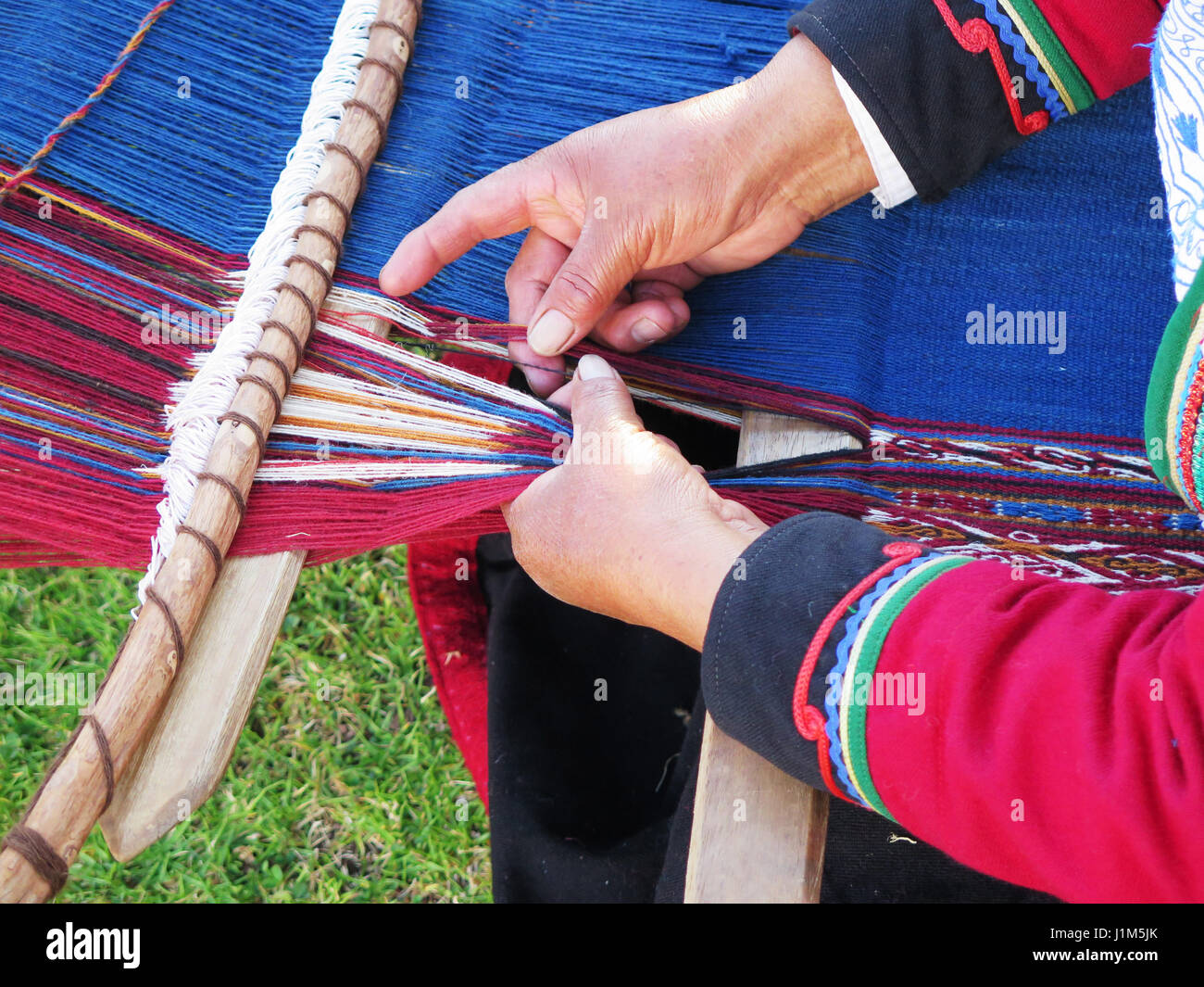 Close up of Peruvian lady in authentic dress spinning yarn by hand ...