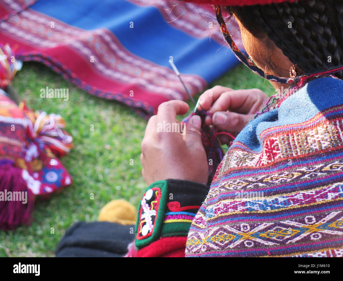 Close up of Peruvian lady in authentic dress spinning yarn by hand ...