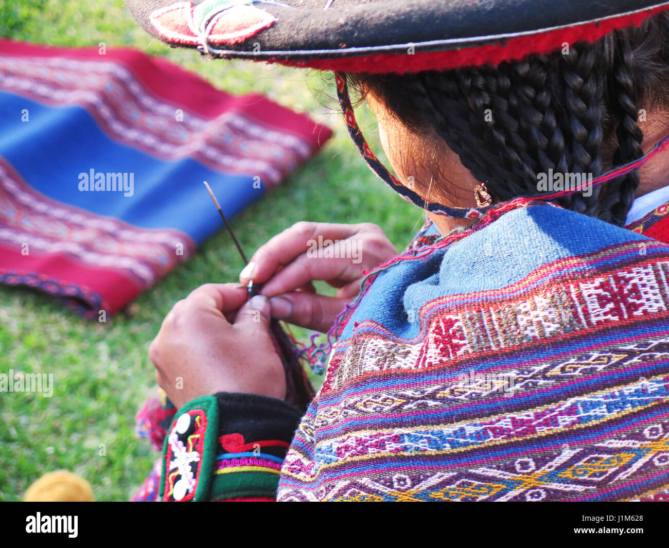 Close up of Peruvian lady in authentic dress spinning yarn by hand ...