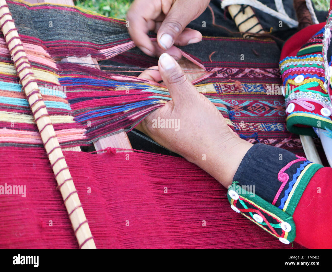 Close up of Peruvian lady in authentic dress spinning yarn by hand ...