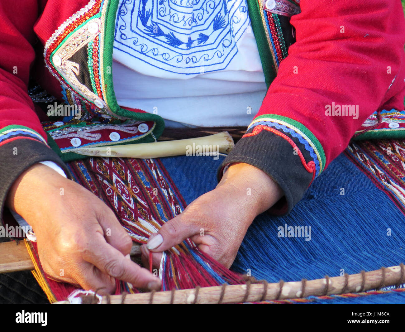 Close up of Peruvian lady in authentic dress spinning yarn by hand ...