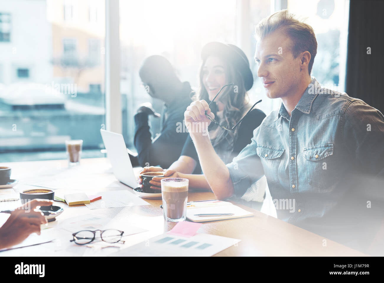 Handsome young Caucasian man in meeting at large conference table in ...