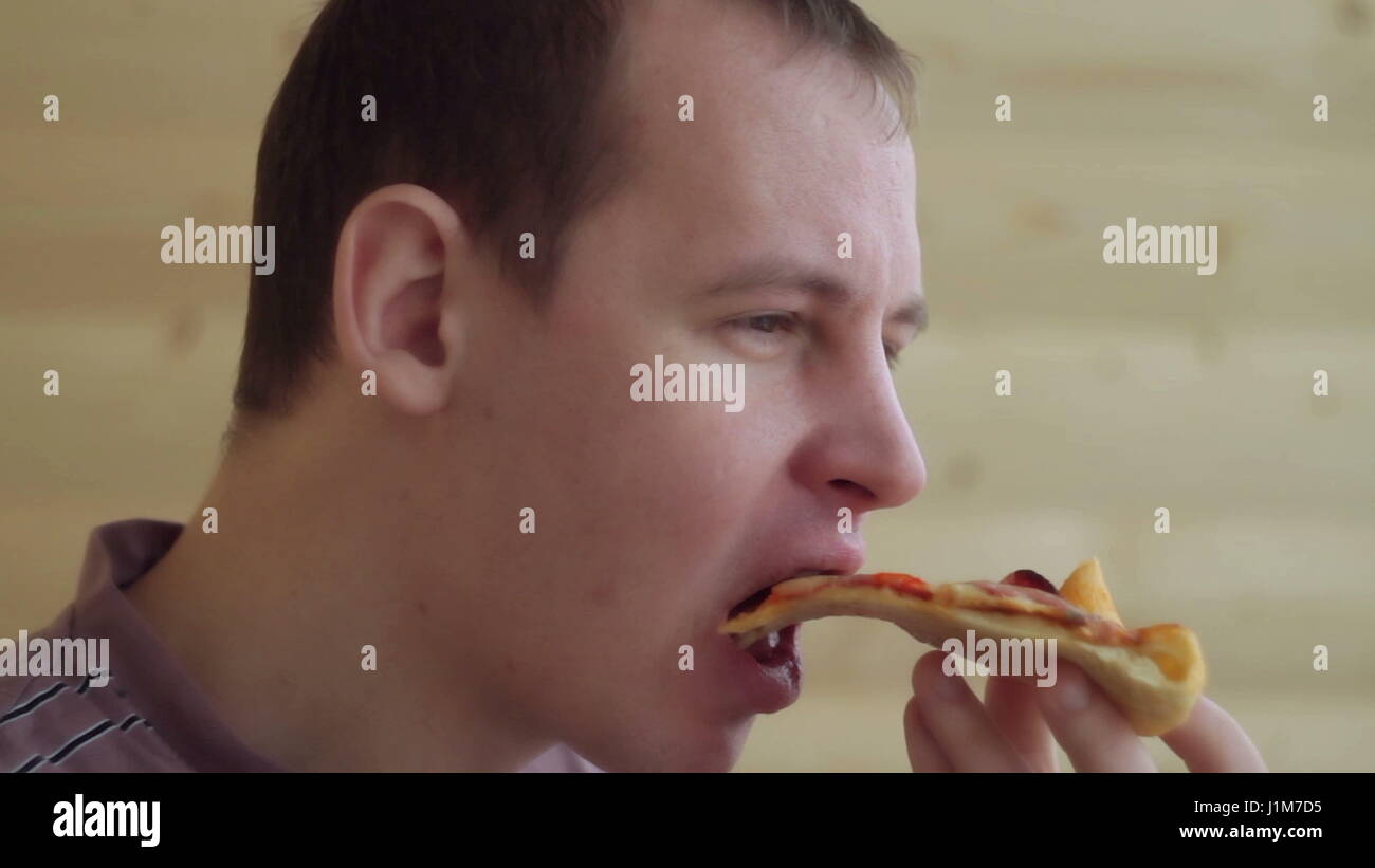 young man eating pizza. mmm tasty food Stock Photo - Alamy