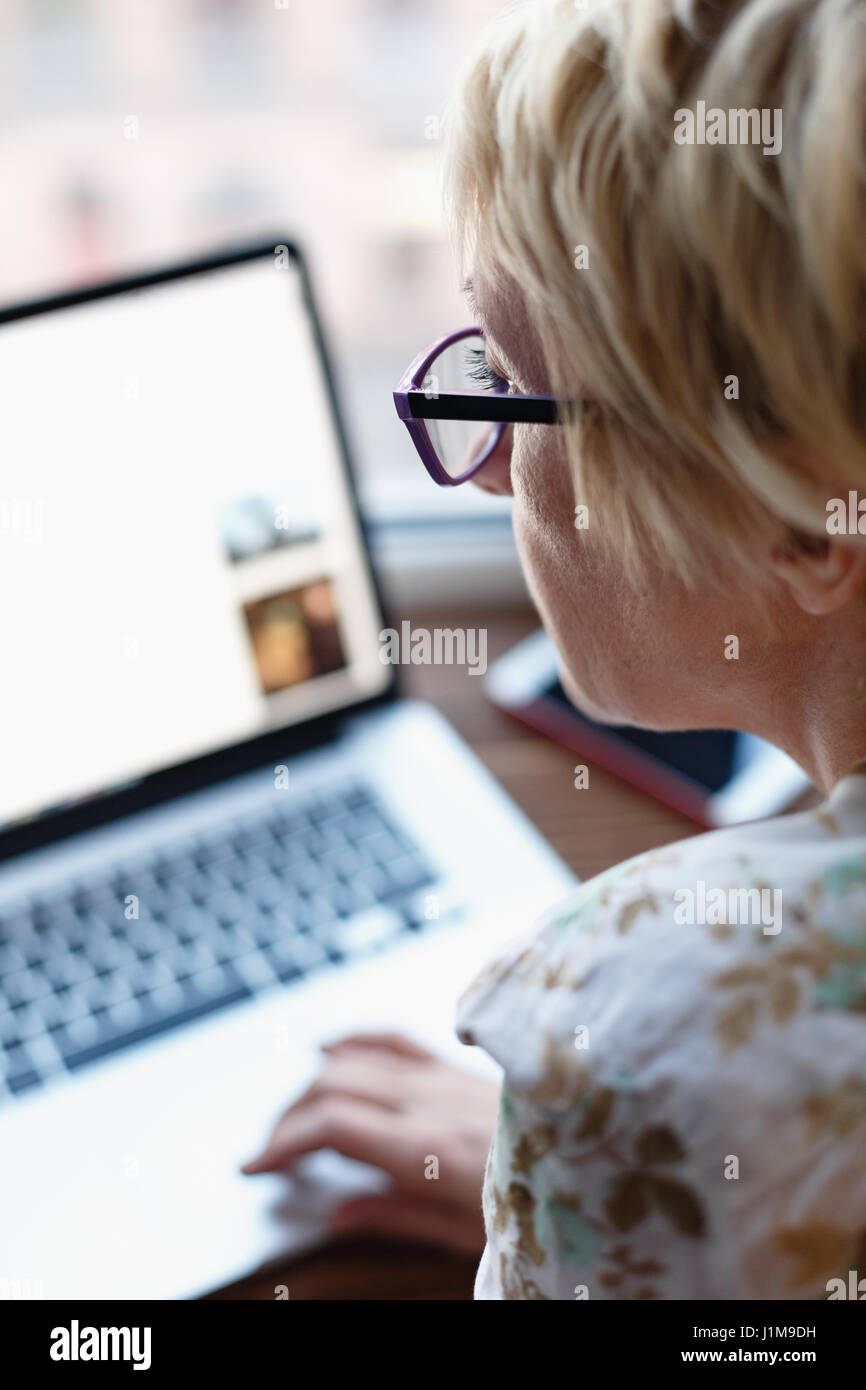 Back view of woman using laptop Stock Photo - Alamy