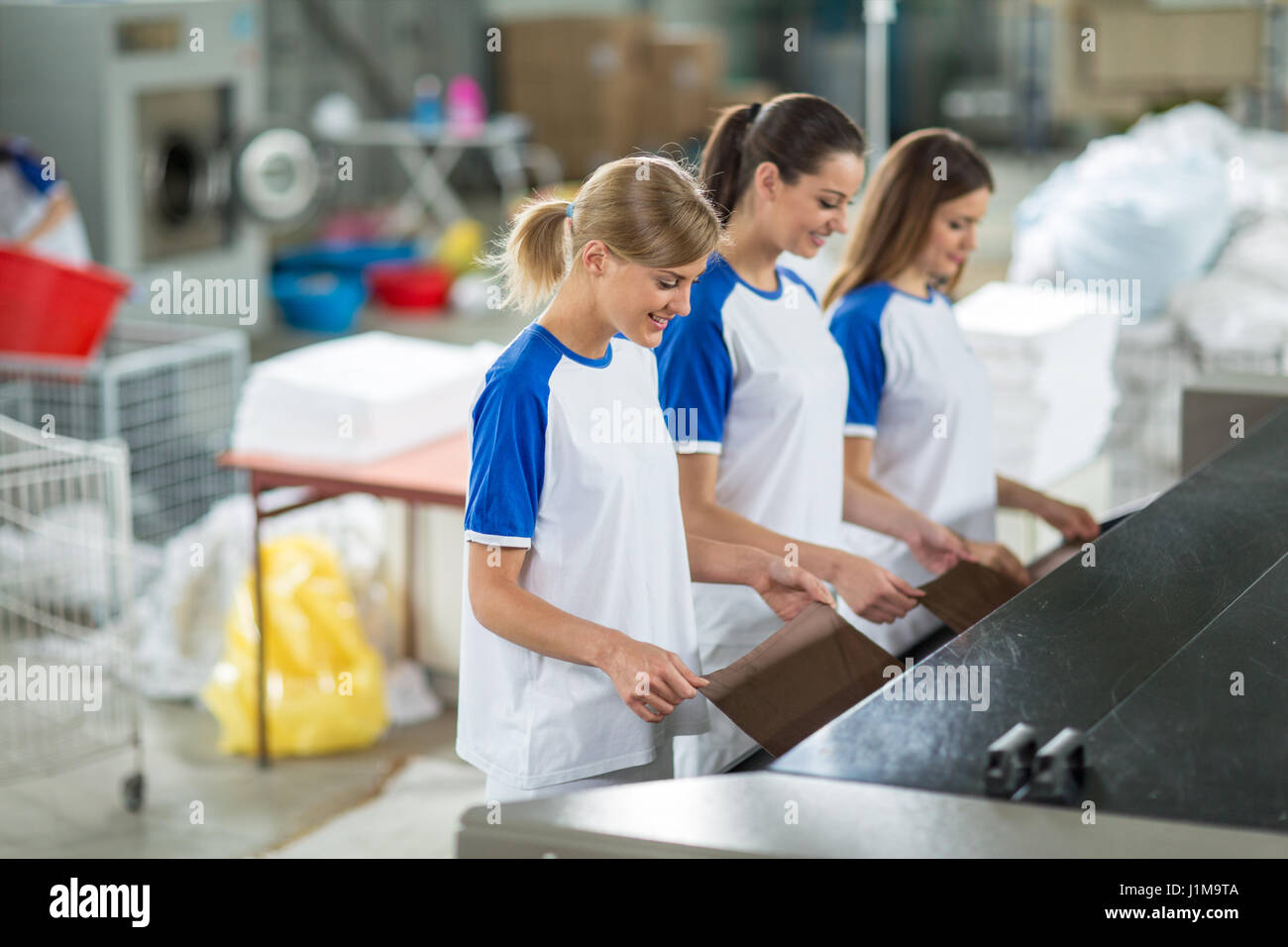 Smiling employee the ironing of machines Stock Photo - Alamy
