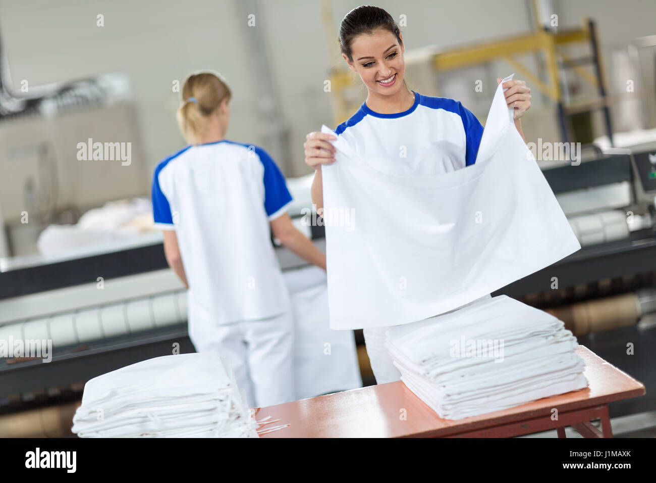 Employee agree ironing textiles in dry cleaner Stock Photo - Alamy
