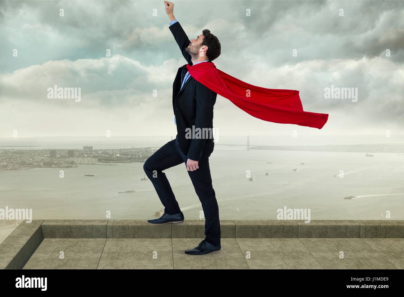 Digital composite of Businessman wearing cape with arm raised while ...