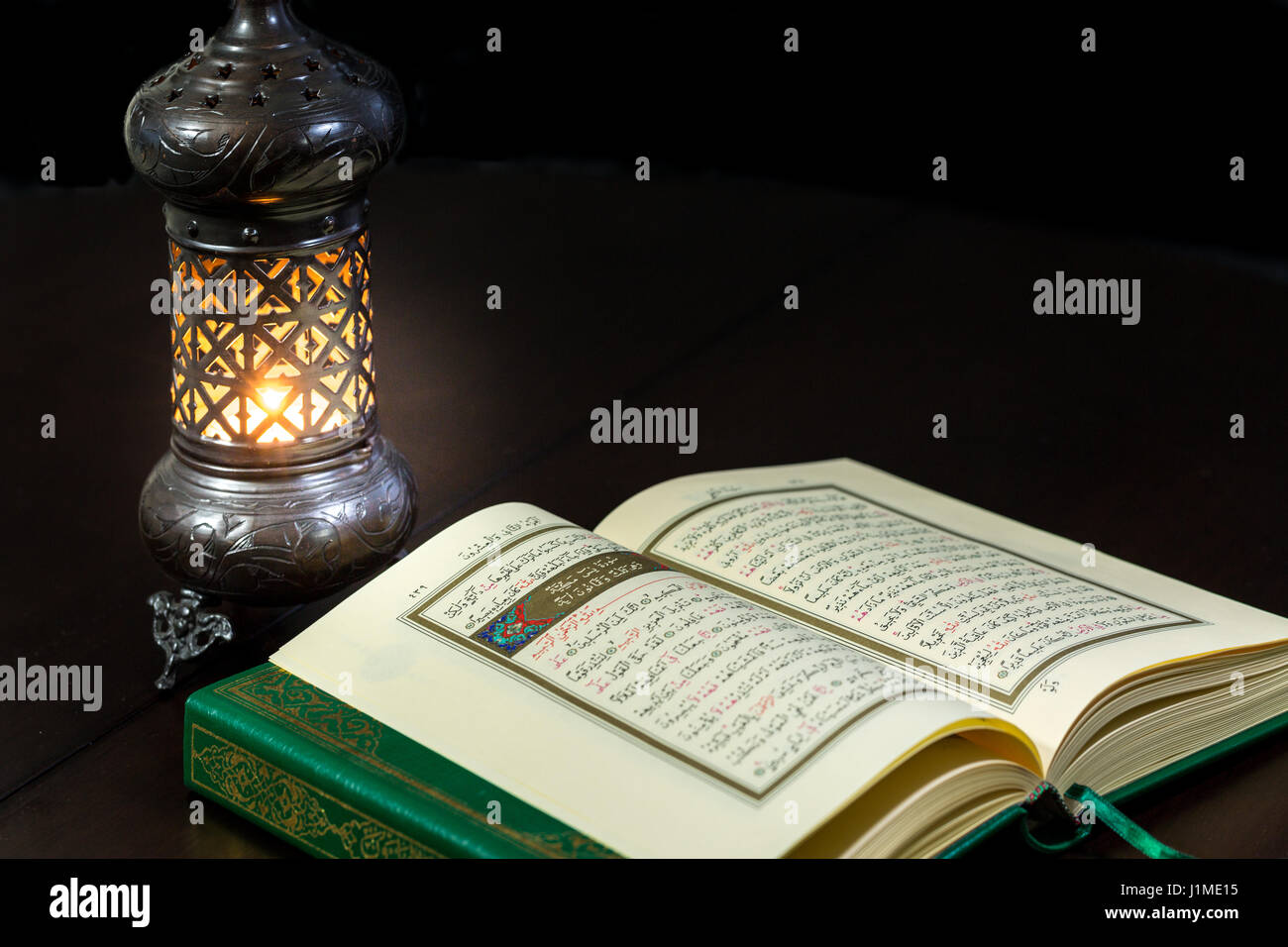 Pages of holy book Qur'an with vintage lamp and dark background Stock ...