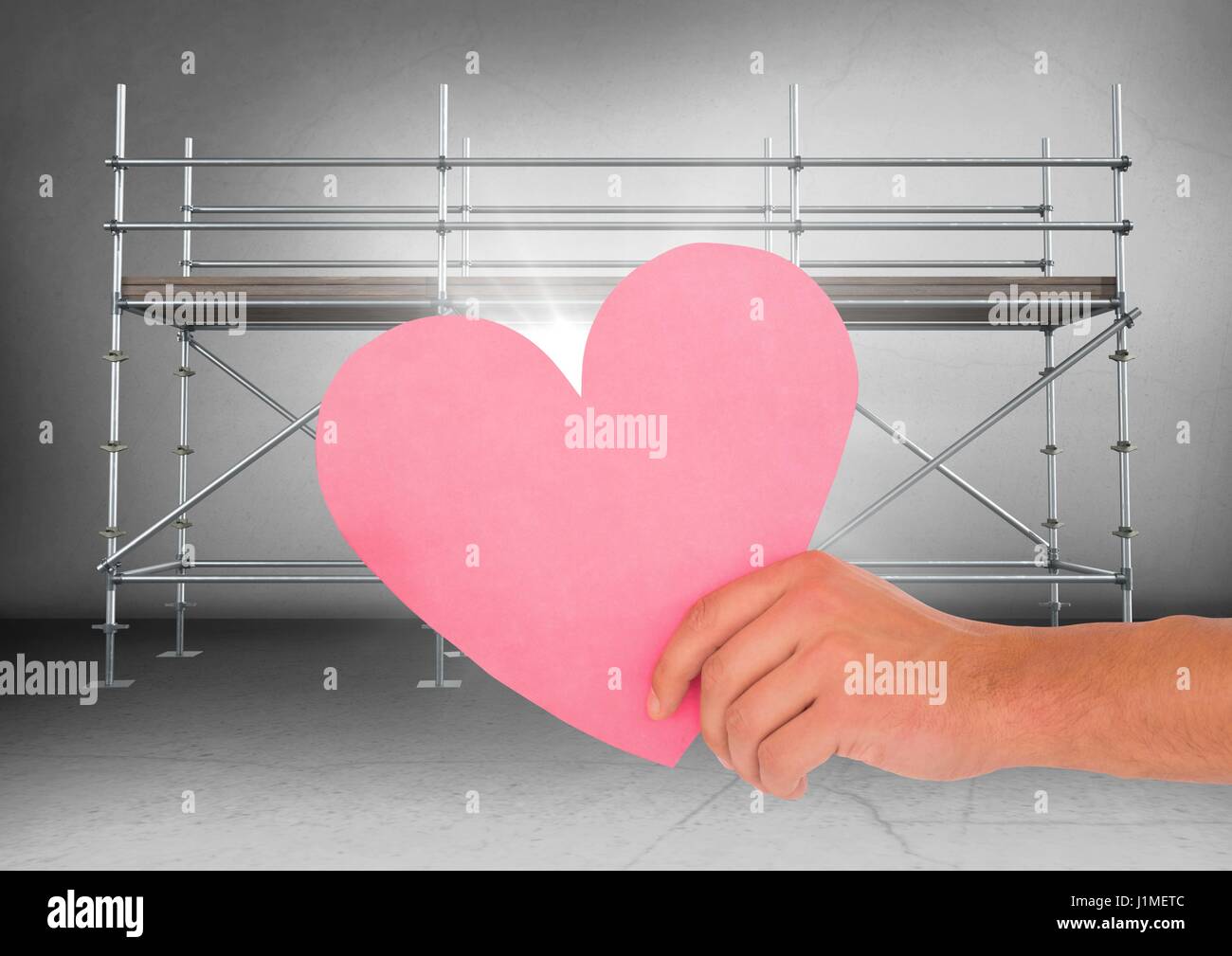 Digital composite of Hand with heart and flare in front of scaffolding ...