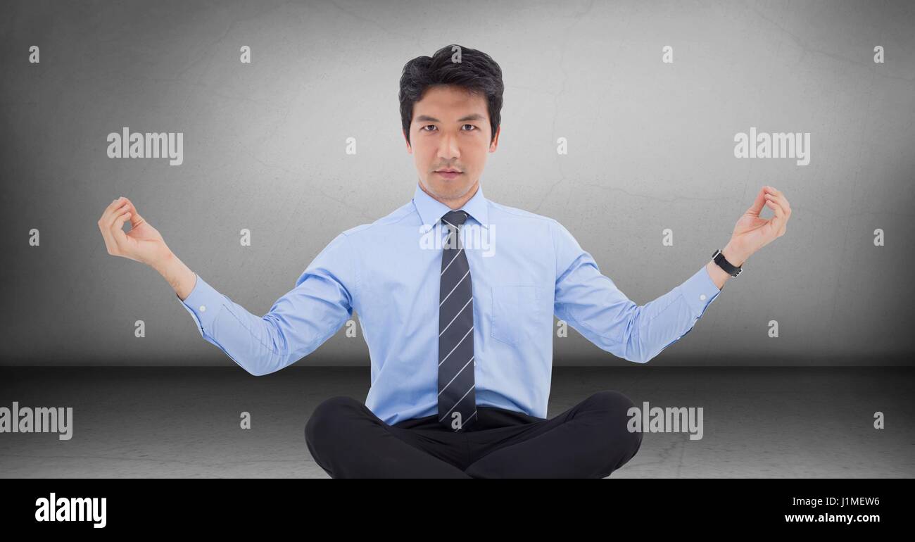 Digital composite of Business man meditating in grey room Stock Photo ...