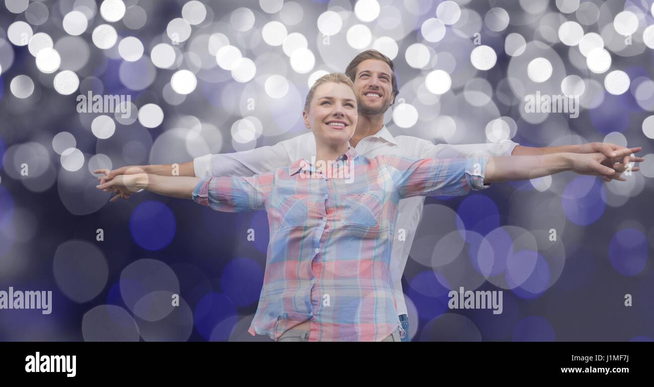 Digital composite of Loving couple with arms outstretched standing ...