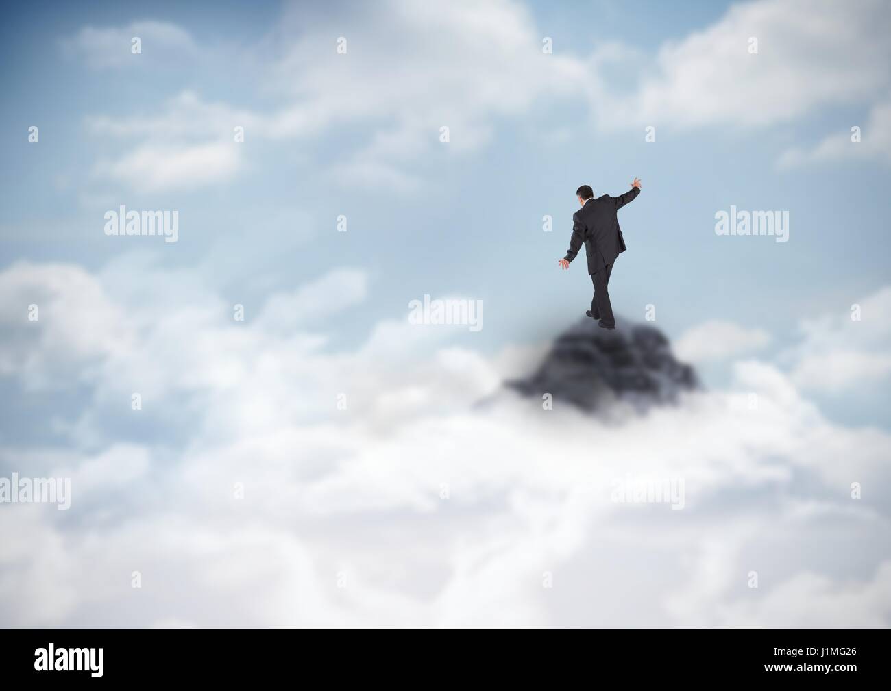 Digital composite of Business man losing balance on mountain peak in ...
