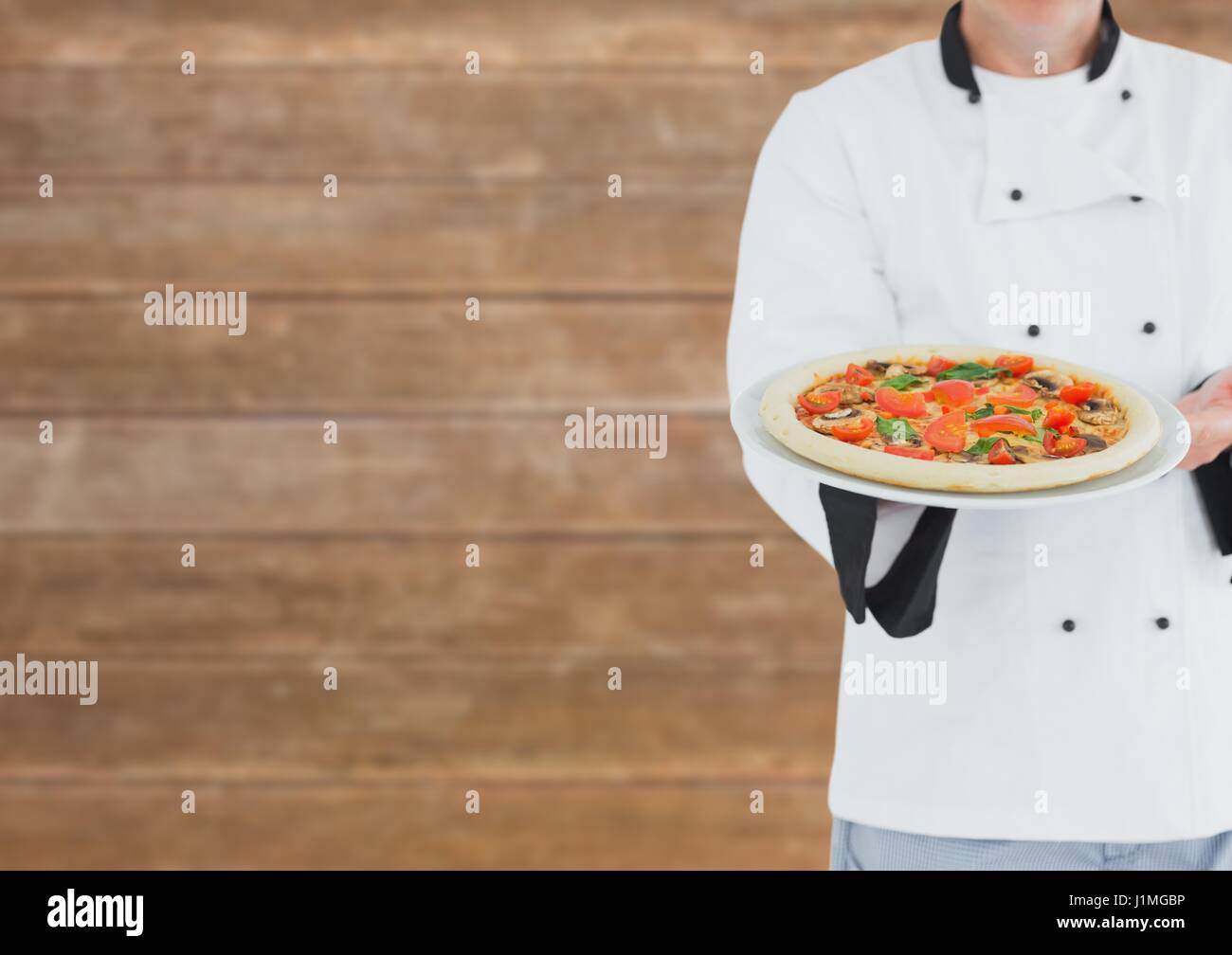 Digital composite of Chef showing the pizza. Blurred wood background ...
