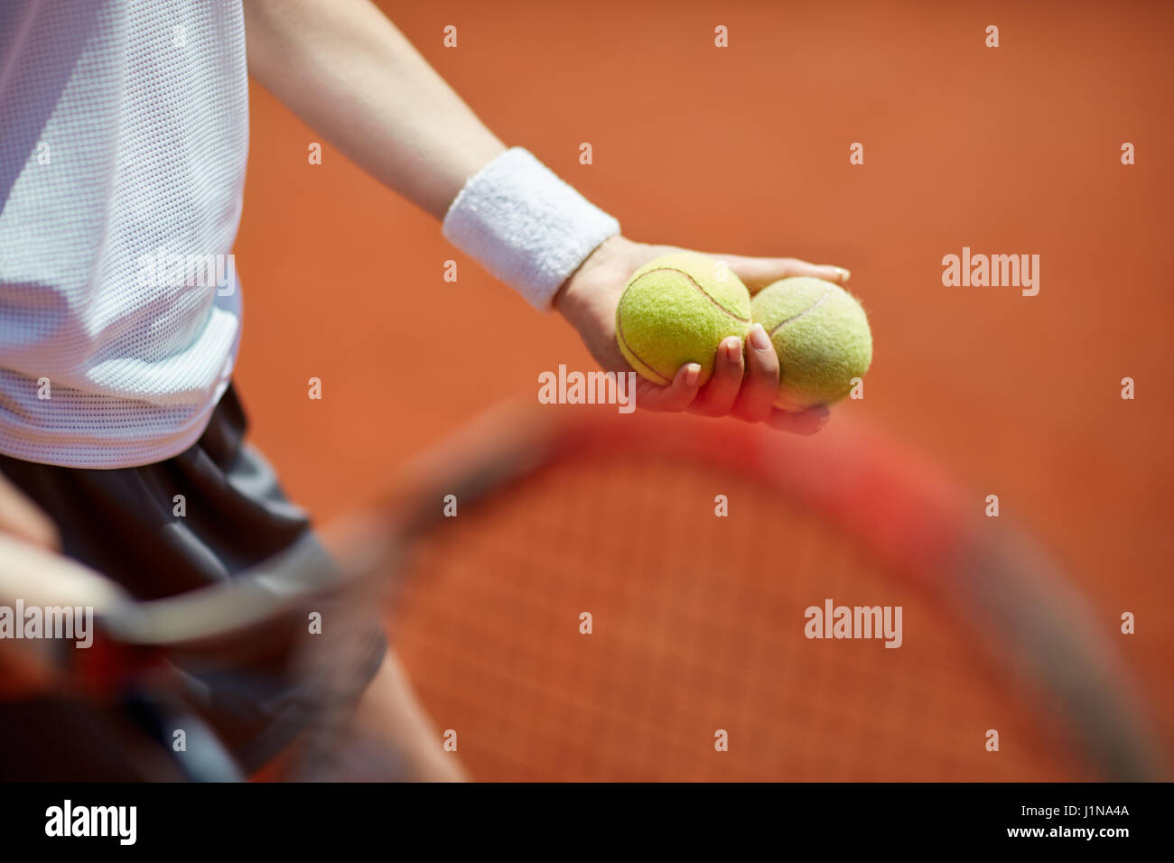 Close up of tennis balls in player’s hand on tennis court Stock Photo ...